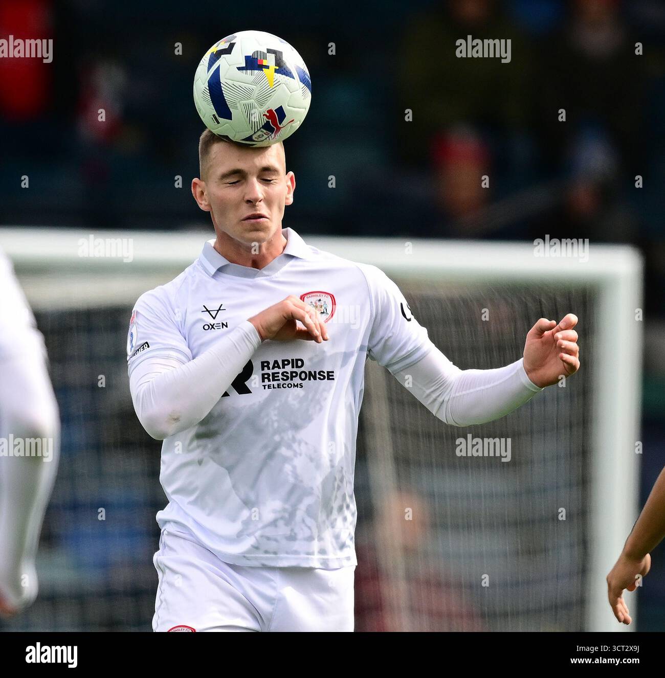 Barnsley's Jonathan Bland heads the ball in the match between Wycombe ...