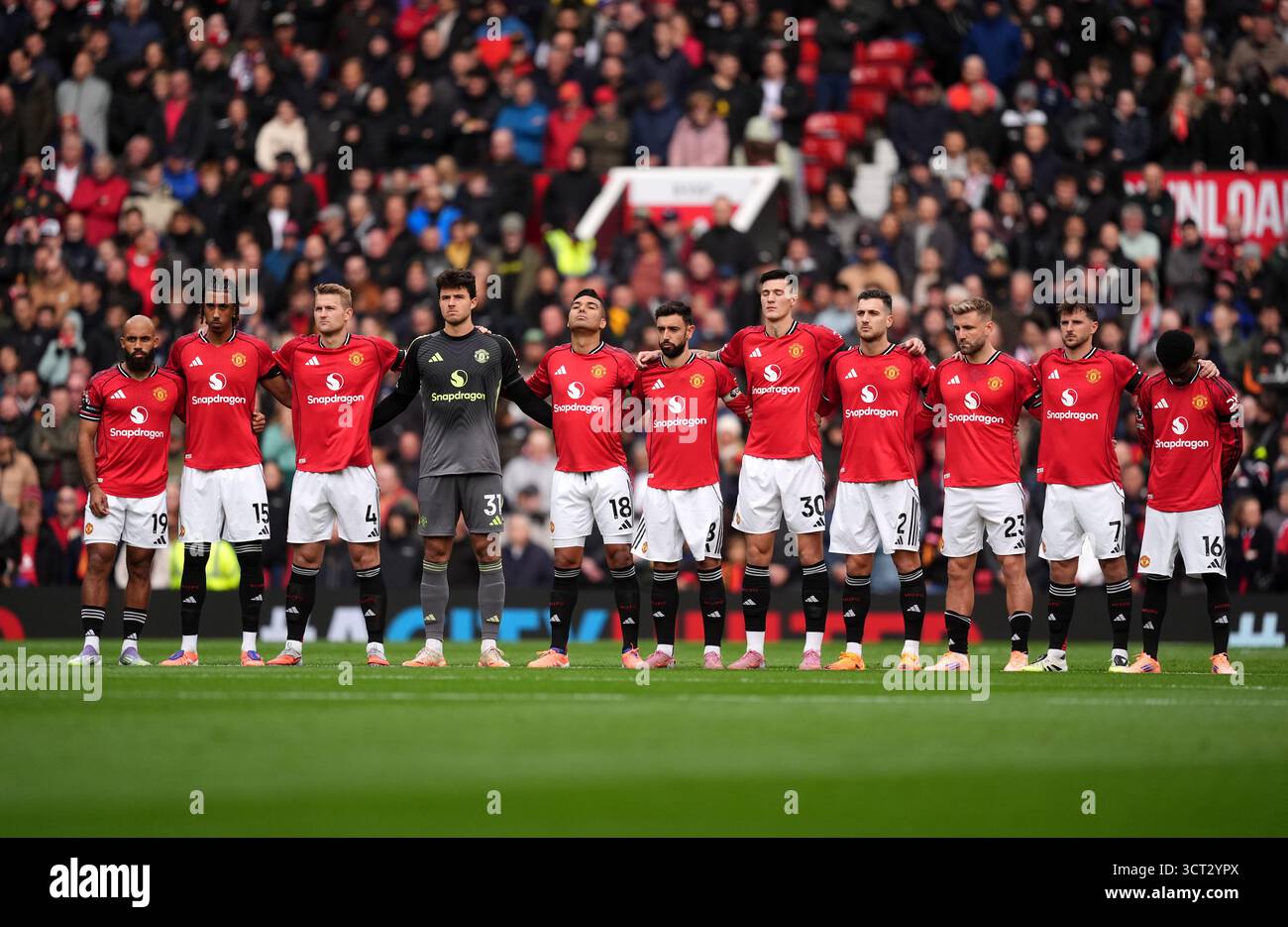Manchester United players observe a minutes' silence in a mark of ...