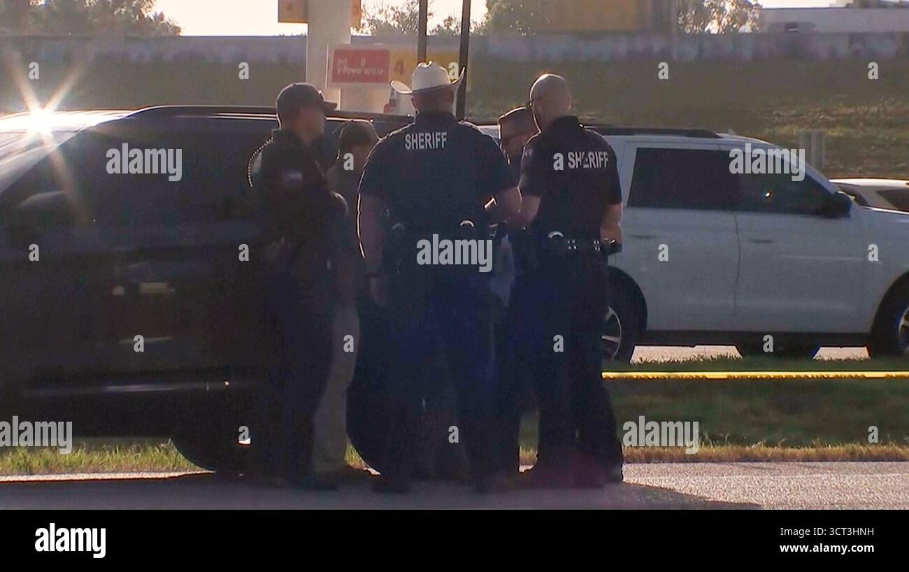 Law enforcement officials investigate a vehicle near the scene of a ...