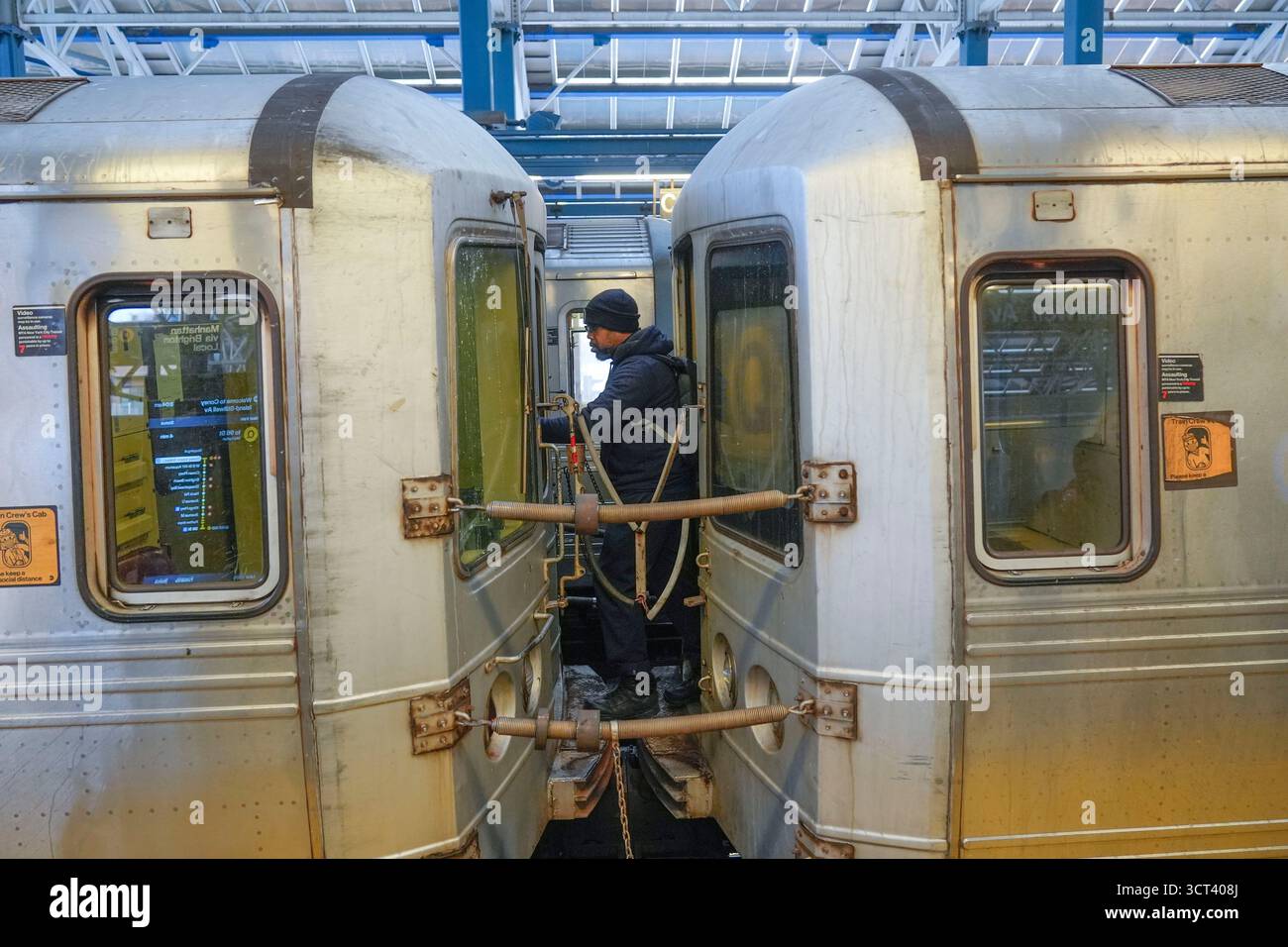 FILE - A train conductor walks between subway cars at a station in the ...