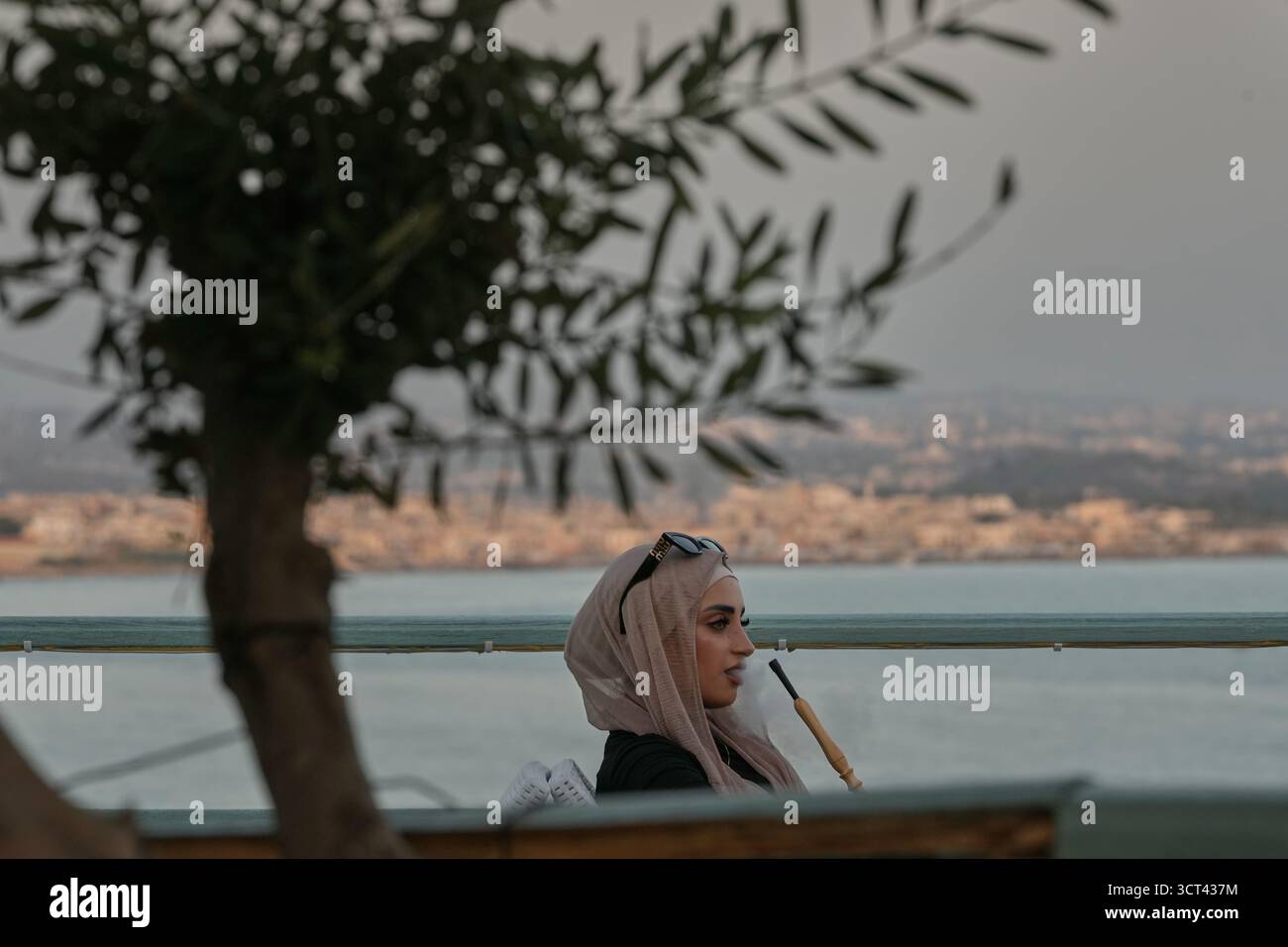 A Syrian woman smokes a shisha water pipe as she enjoying on Latakia's ...
