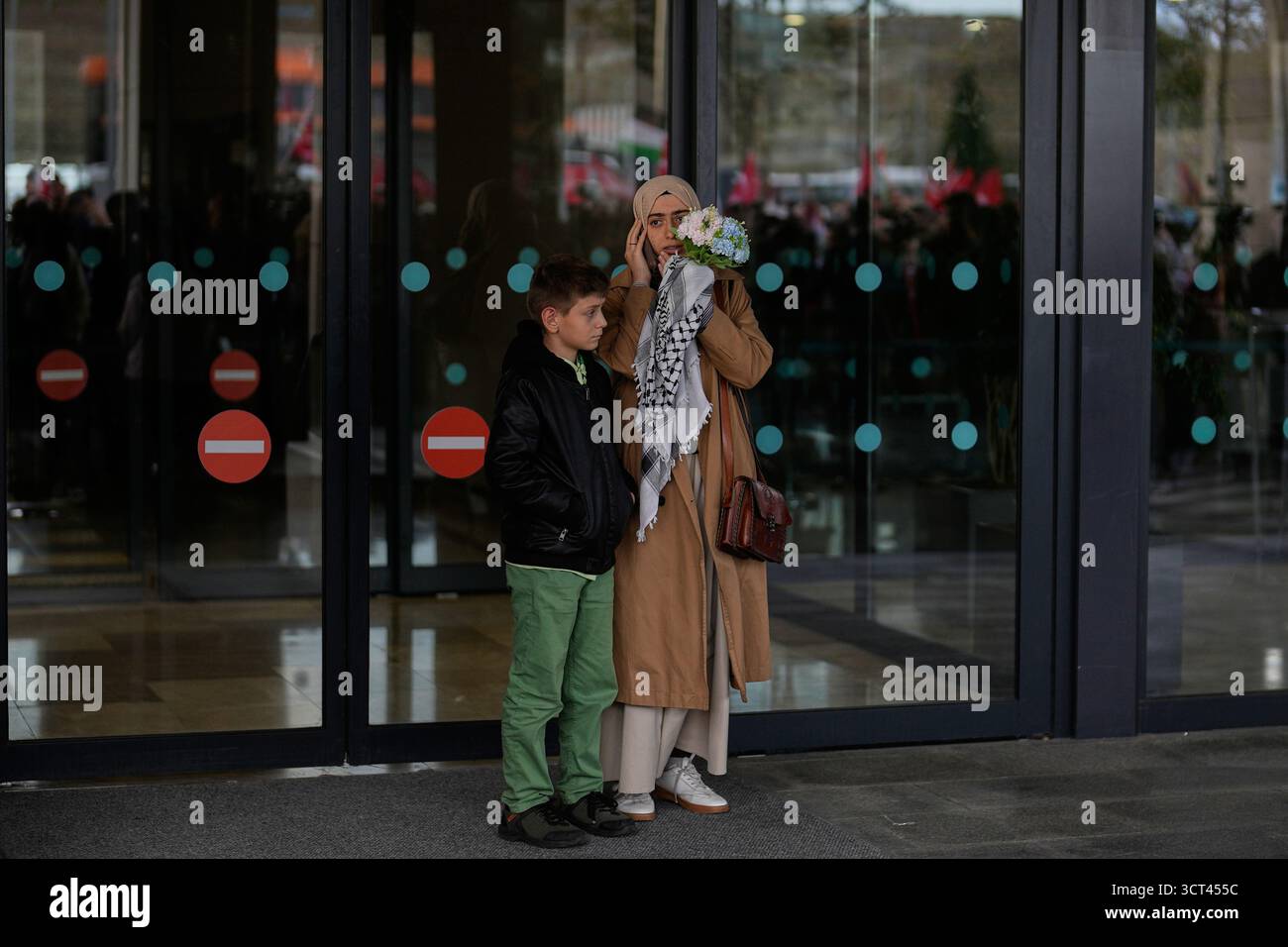 A woman holding flowers waits outside Istanbul Airport for the arrival ...
