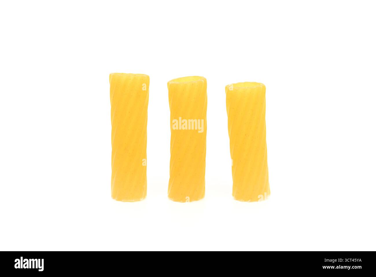 Three yellow pasta tubes are on a white background. The pasta tubes are ...
