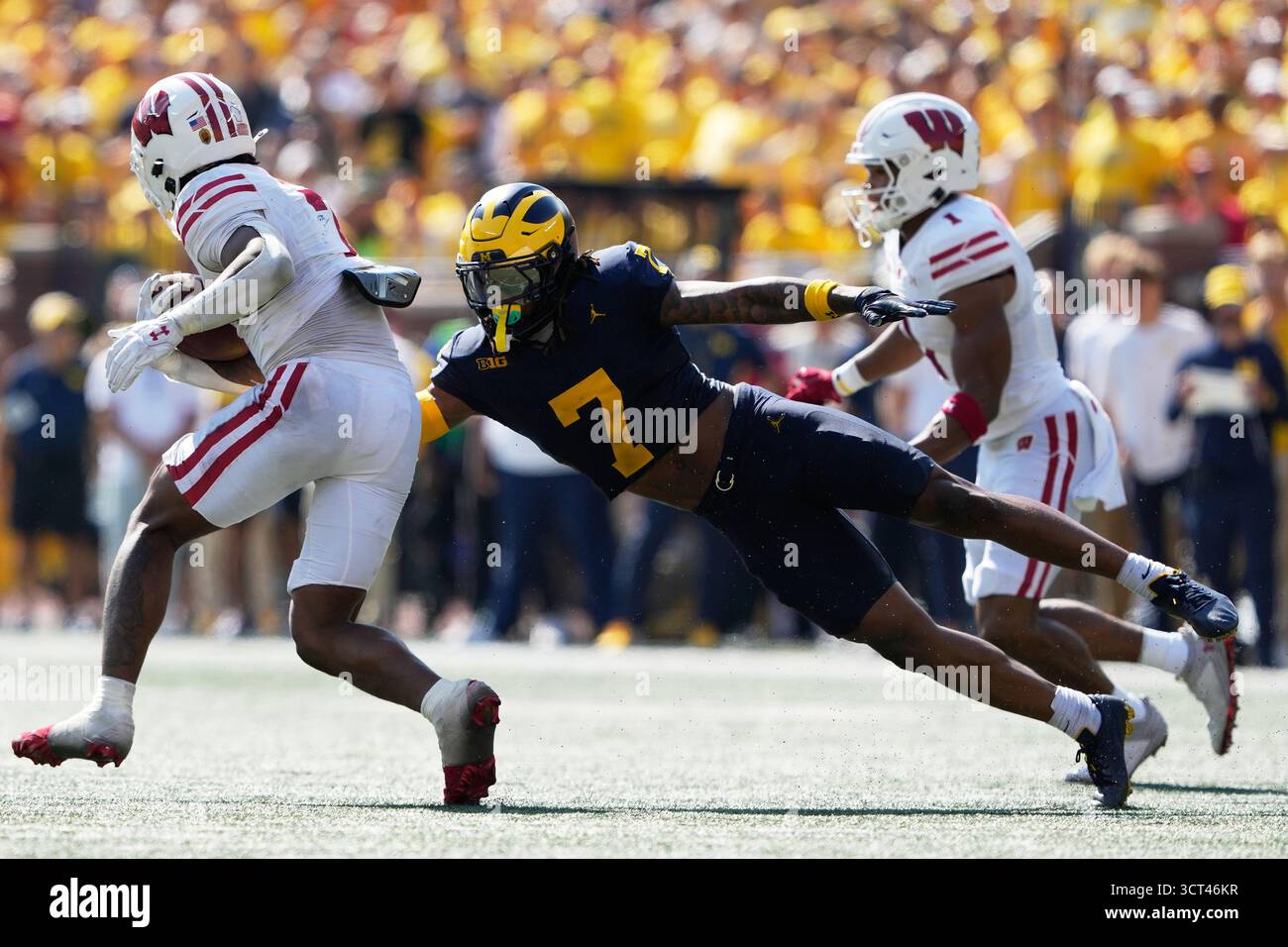 Michigan defensive back TJ Metcalf, right, tackles Wisconsin running ...