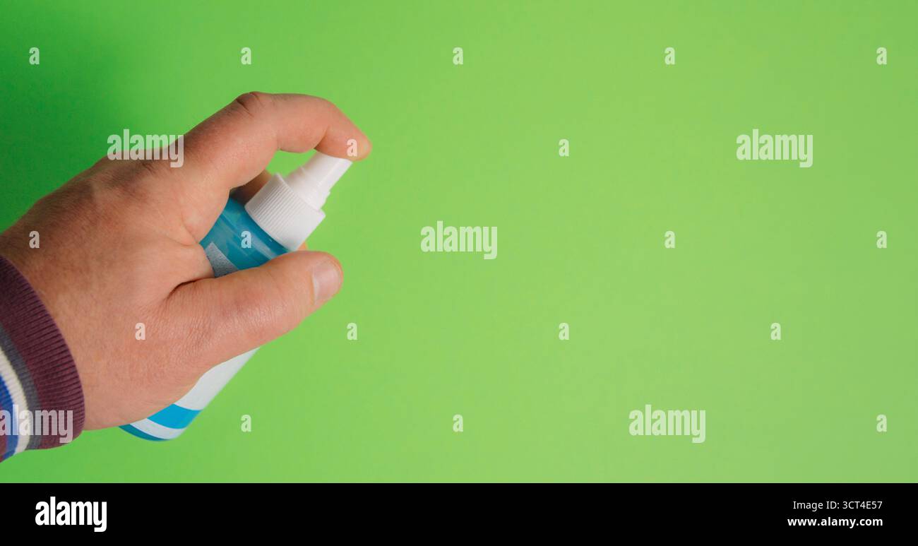 Hand holding spray bottle spraying white paint on wall hi-res stock ...