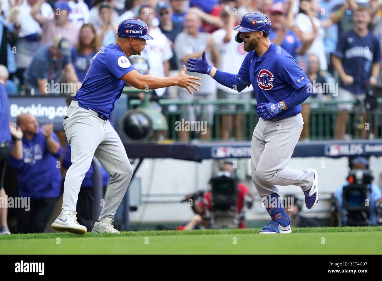 Chicago Cubs' Michael Busch, right, high-fives third base coach Quinton ...