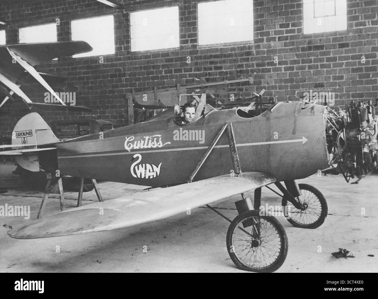 William G Swan sitting in the cockpit of a training plane he invented ...
