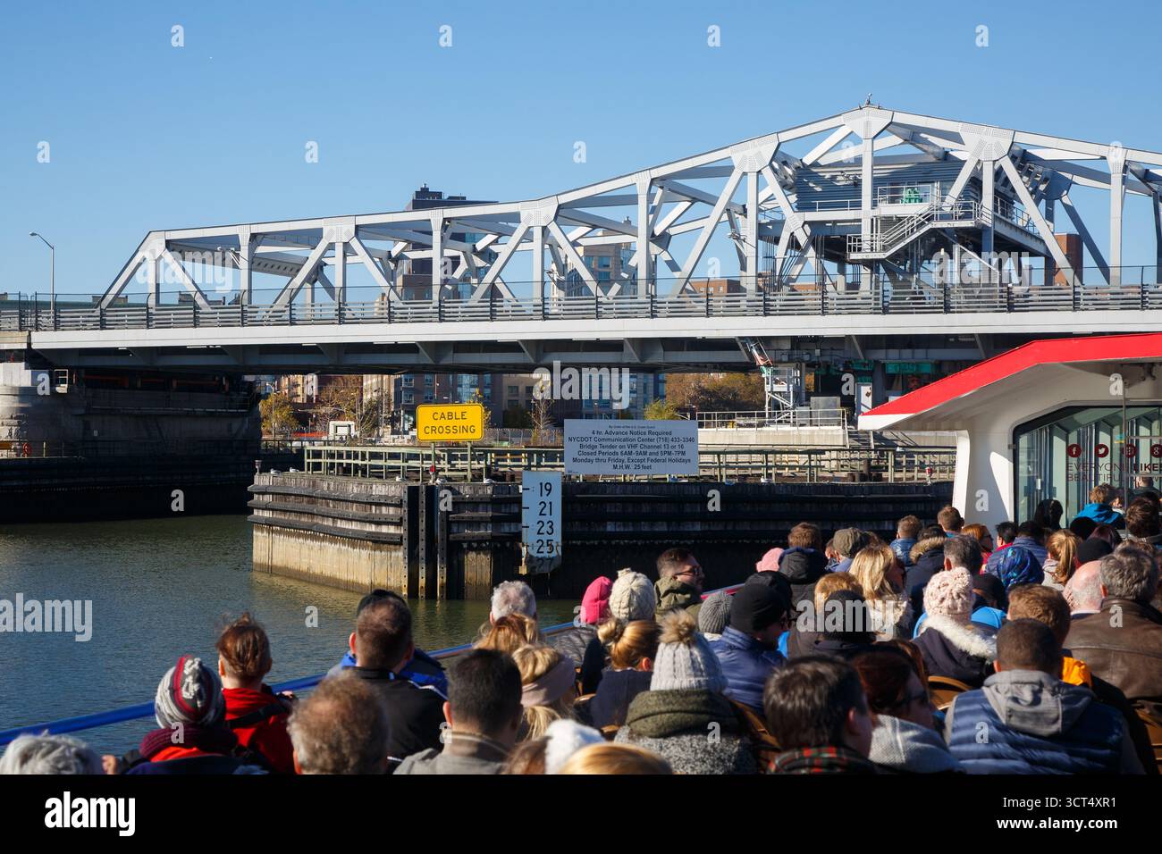 Group of Tourists on a tour boat and the Third Avenue Bridge over ...