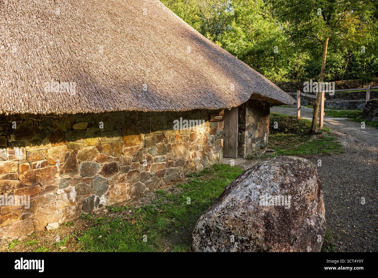 Stone and thatch dining hall of a monastic settlement with gravel path ...