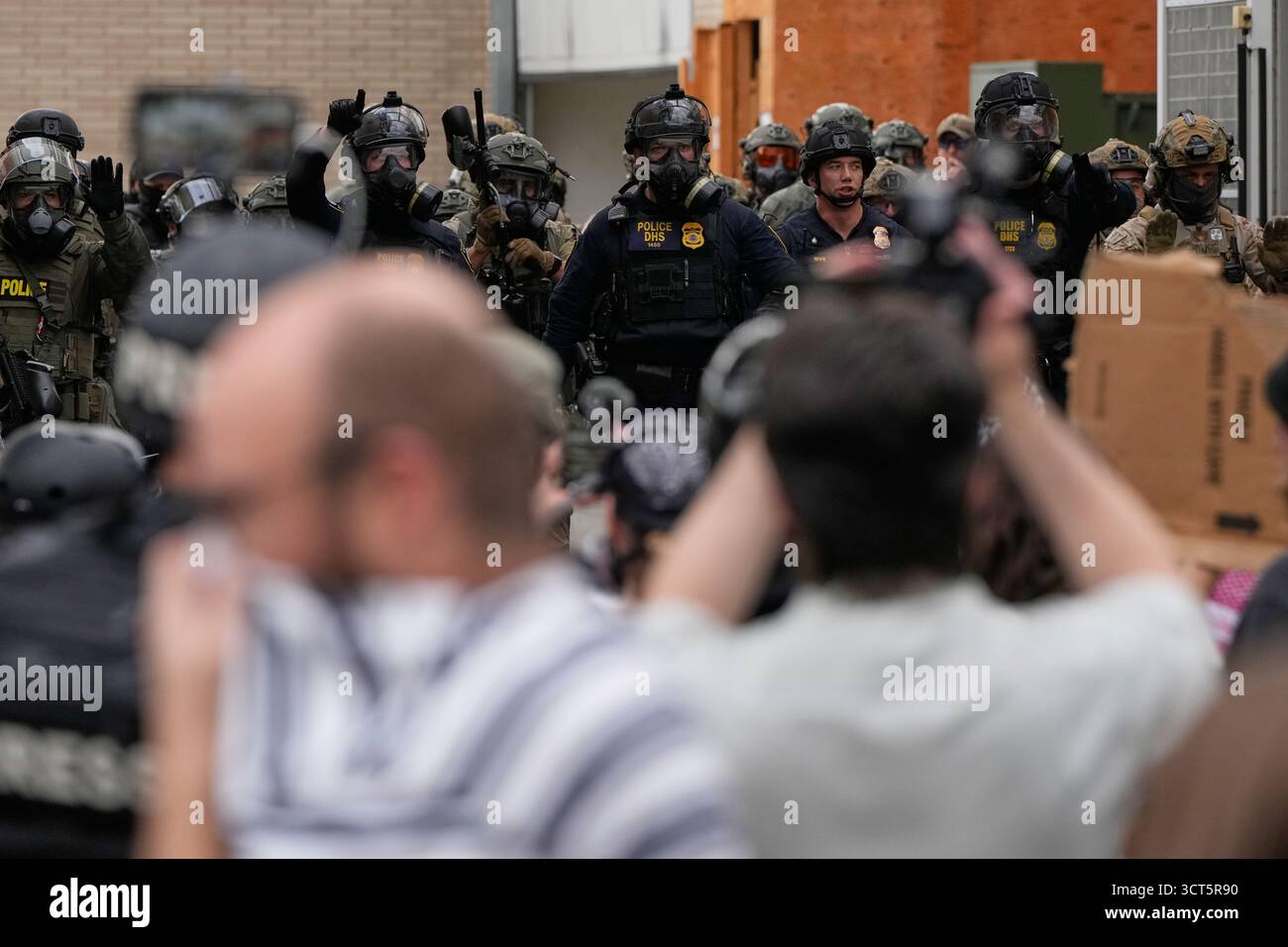 Law enforcement officers standoff against demonstrator outside a U.S ...