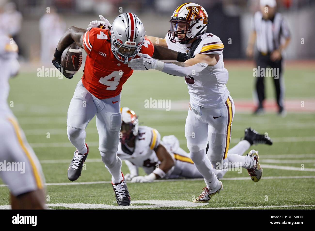Ohio State receiver Jeremiah Smith, left, stiff arms Minnesota ...