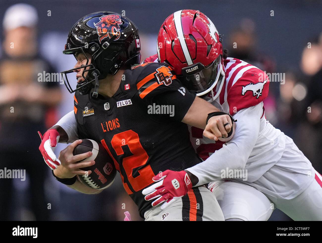 B.C. Lions quarterback Nathan Rourke, front left, is sacked by Calgary Stampeders' Clarence ...