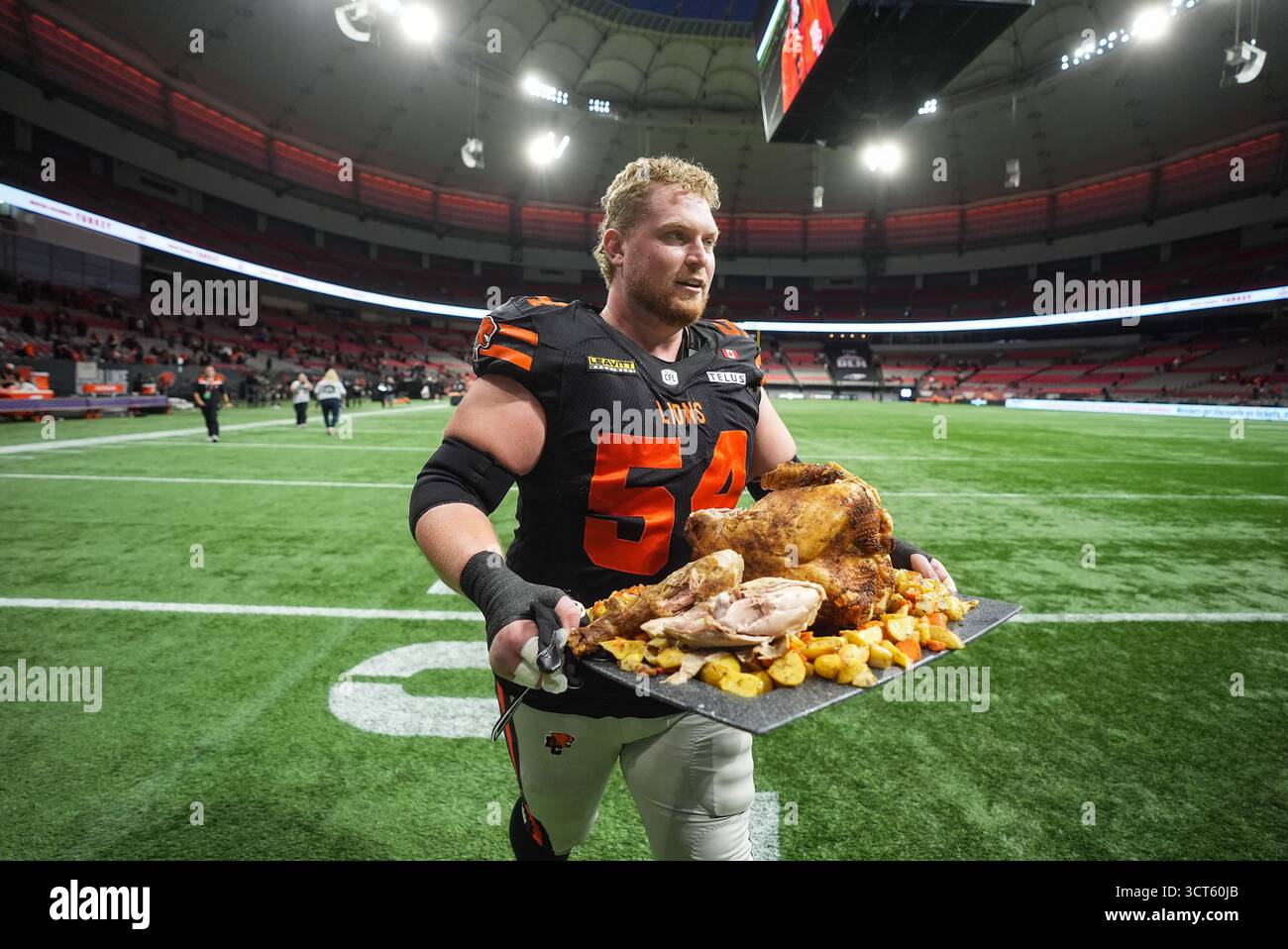 B.C. Lions' Andrew Peirson carries a turkey as he leaves the field ...