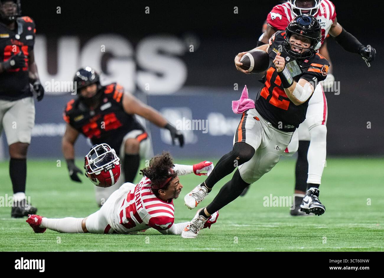 B.C. Lions quarterback Nathan Rourke (12) gets away from Calgary Stampeders' Jaydon Grant (25 ...
