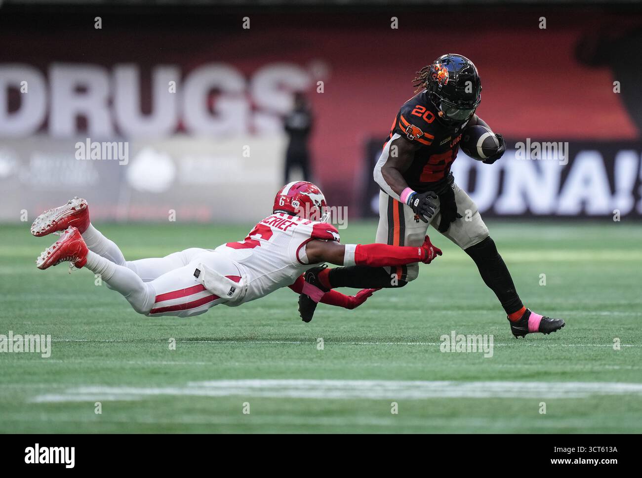 B.C. Lions' James Butler (20) runs the ball past Calgary Stampeders ...