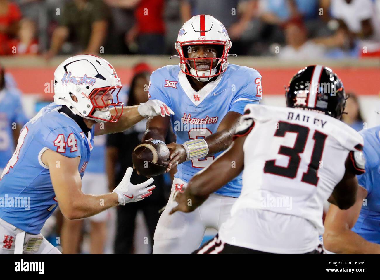 Houston quarterback Zeon Chriss, center, hands off to Houston running ...