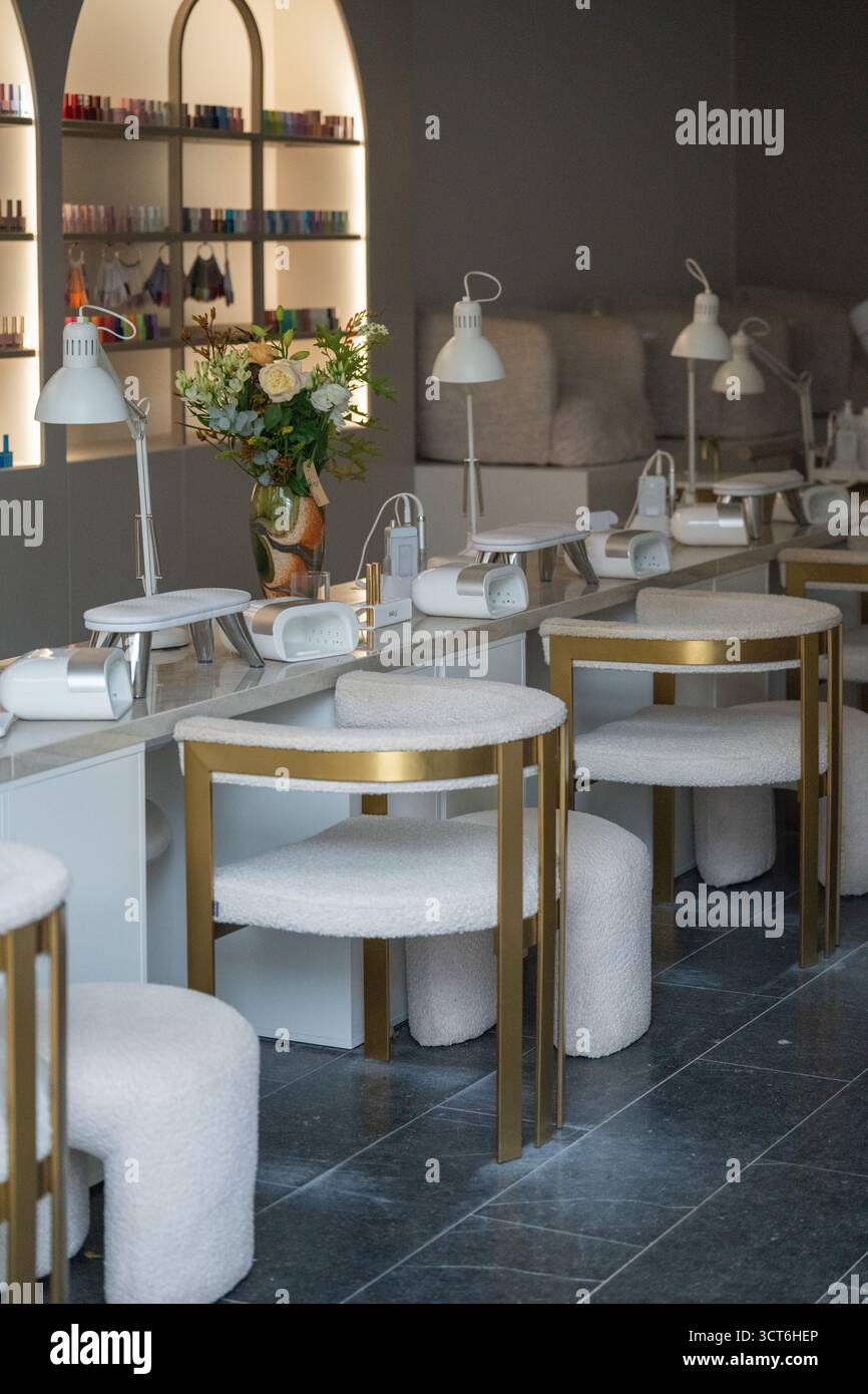 Modern nail salon interior with stylish chairs, tables, and shelves of ...