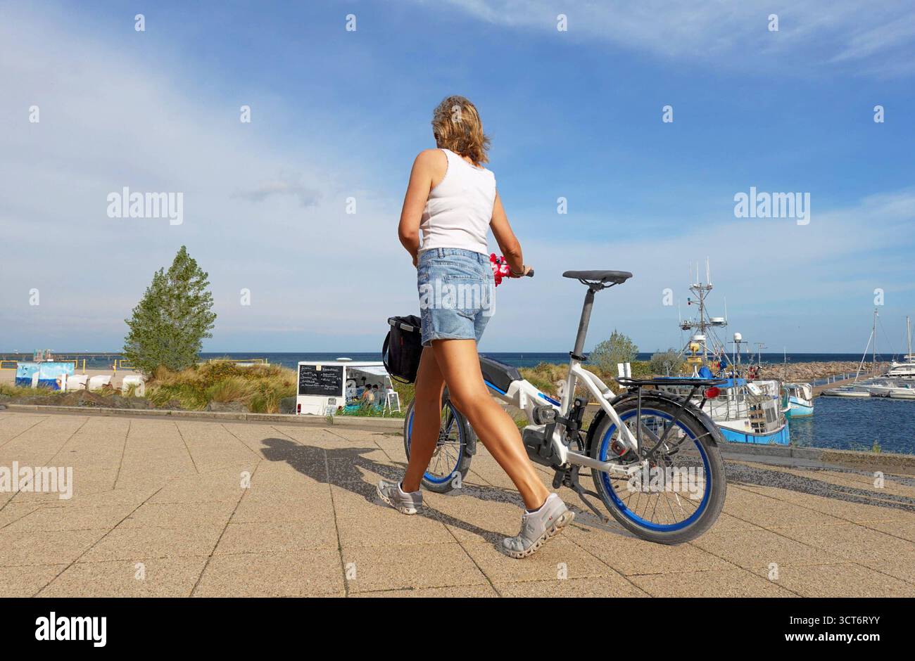 Junge Frau schiebt ihr Fahrrad - hier gesehen Yachthafen vor ...