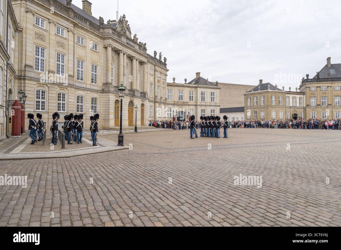 Historic guards in uniform marching on a cobblestone square in front of ...
