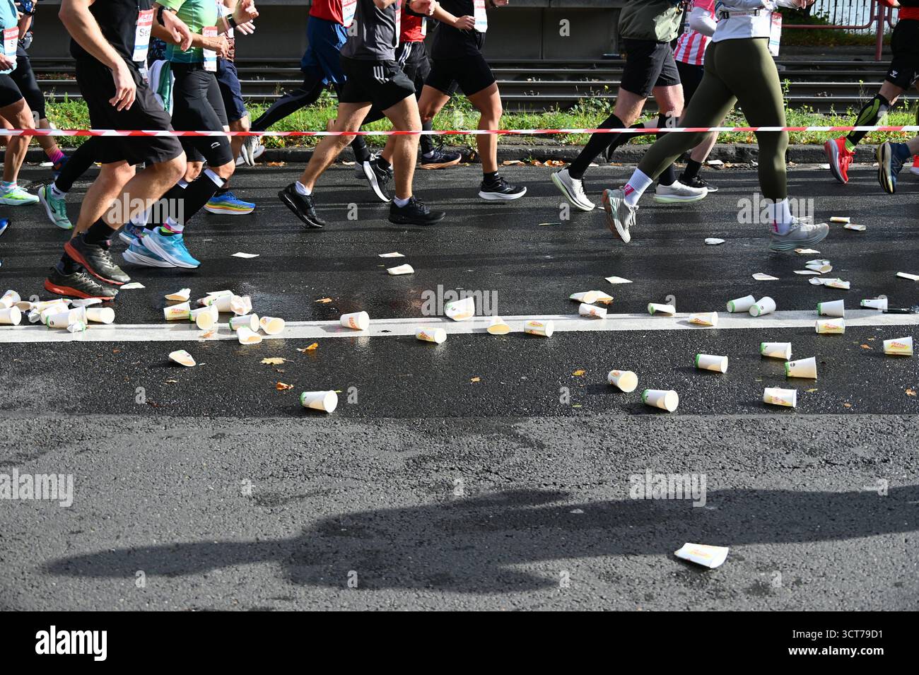 leere Trinkbecher auf der Laufstrecke und Läufer beim Köln Marathon ...