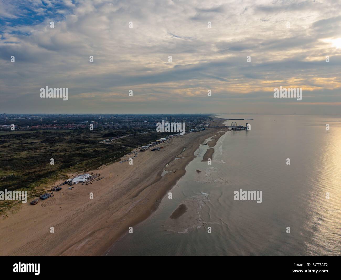 Aerial view of coastal city with long sandy beach, scattered structures ...