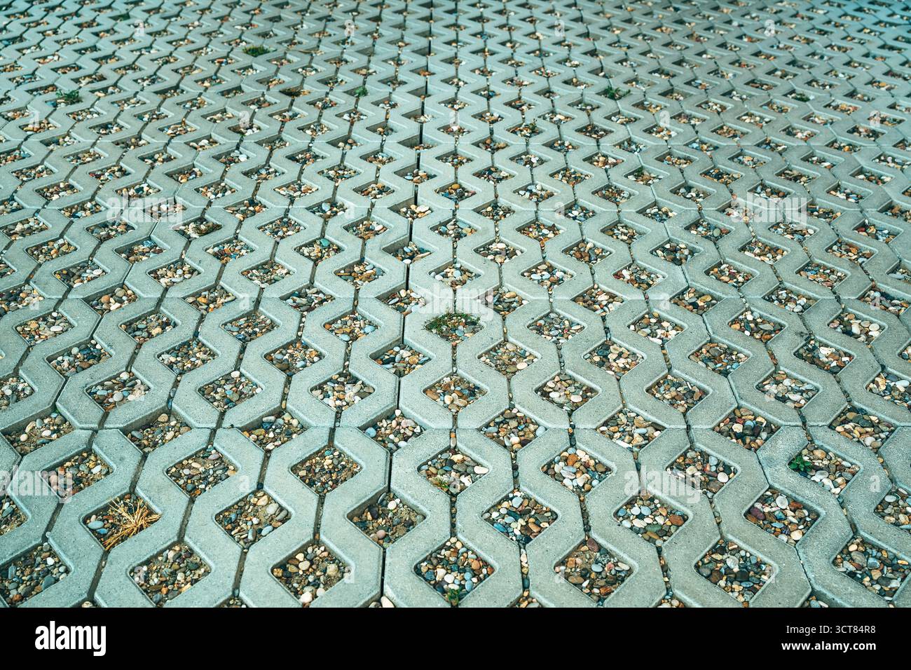 Permeable concrete pavers with gravel stones filling geometric gaps ...