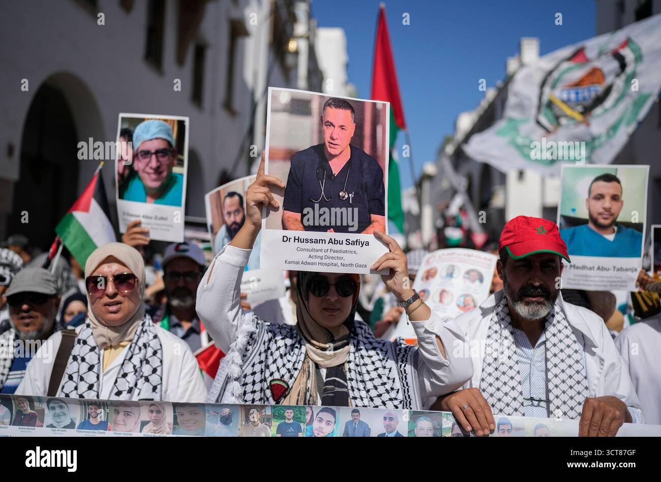 Medical professionals carry photos of Palestinian doctors as thousands ...