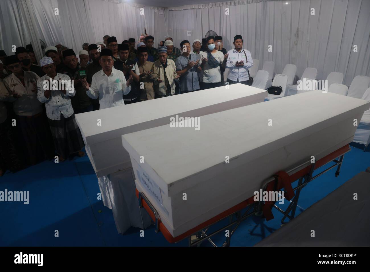Men pray near the coffins containing the body of Nuruddin and Ahmad ...