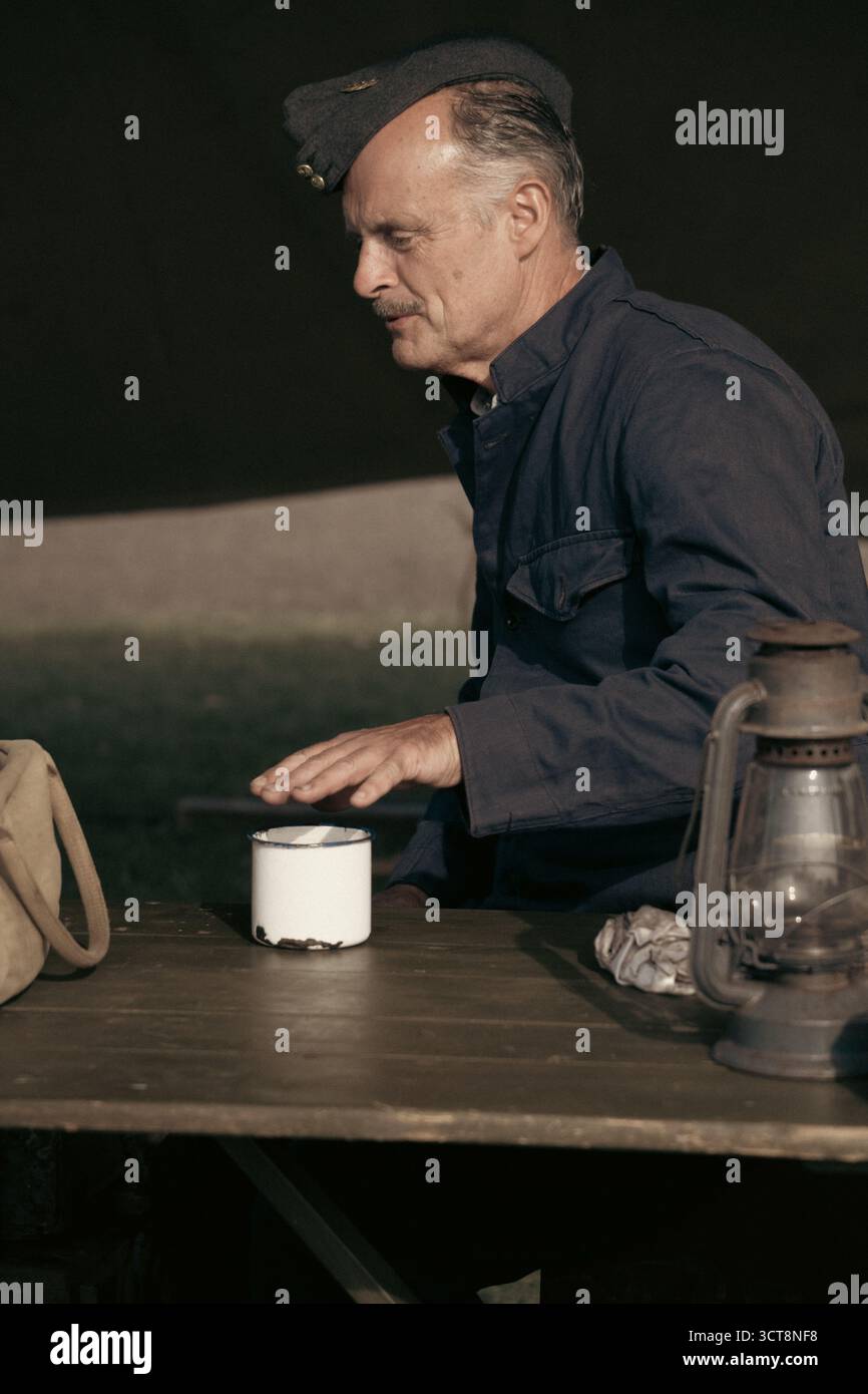 WWII re-enactor in RAF uniform with enamel mug and oil lamp at Duxford ...
