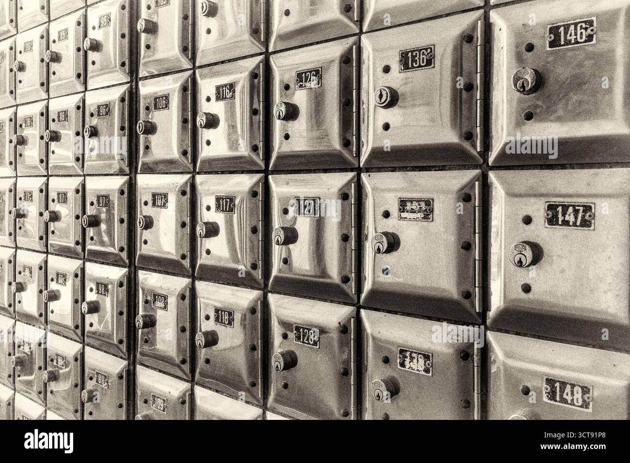 Wall full of rows of old shiny metal post office deposit value boxes ...