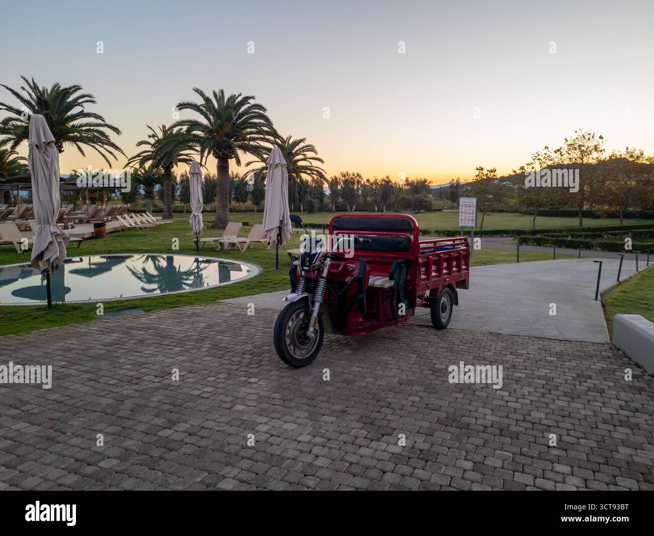 Red three-wheeled utility vehicle parked at a luxury resort during a ...
