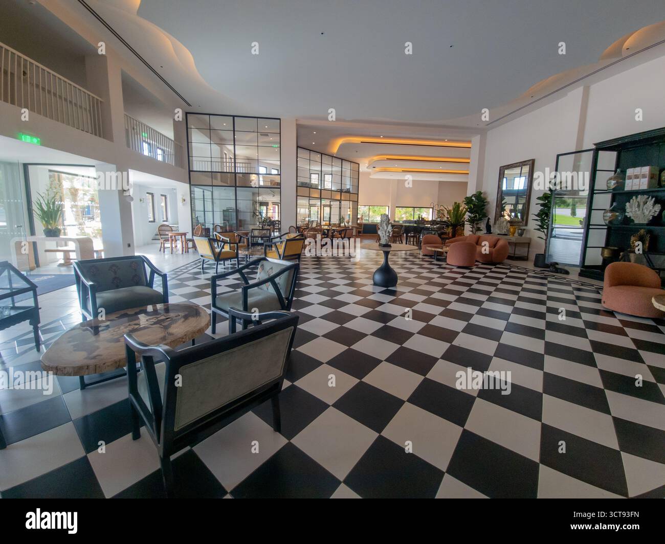 Wide-angle view of a spacious and stylish luxury hotel lobby with a ...