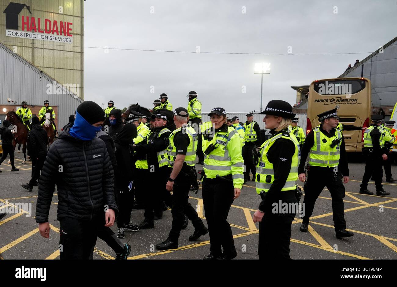 Police officers move Rangers fans back as the Rangers team bus leaves ...