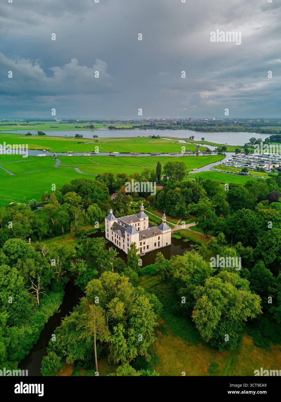 Aerial view of historic castle with moat, surrounded by dense greenery ...