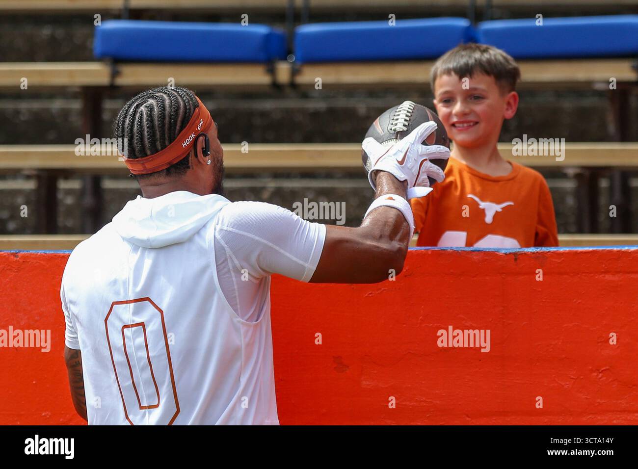 Texas wide receiver DeAndre Moore Jr. (0) plays catch with a young fan ...