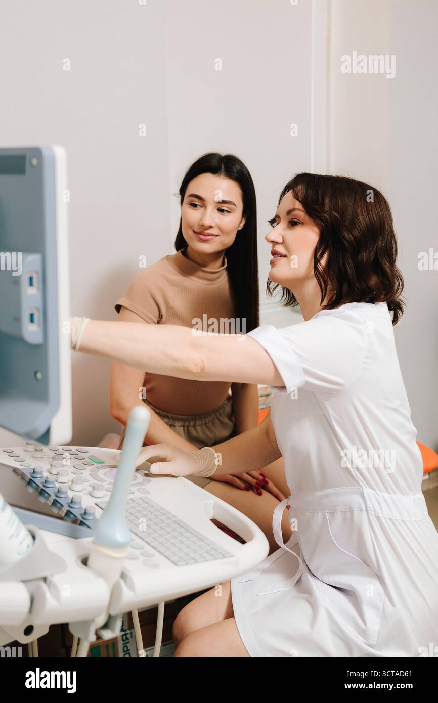 Gynecologist and patient reviewing ultrasound scan results together on ...