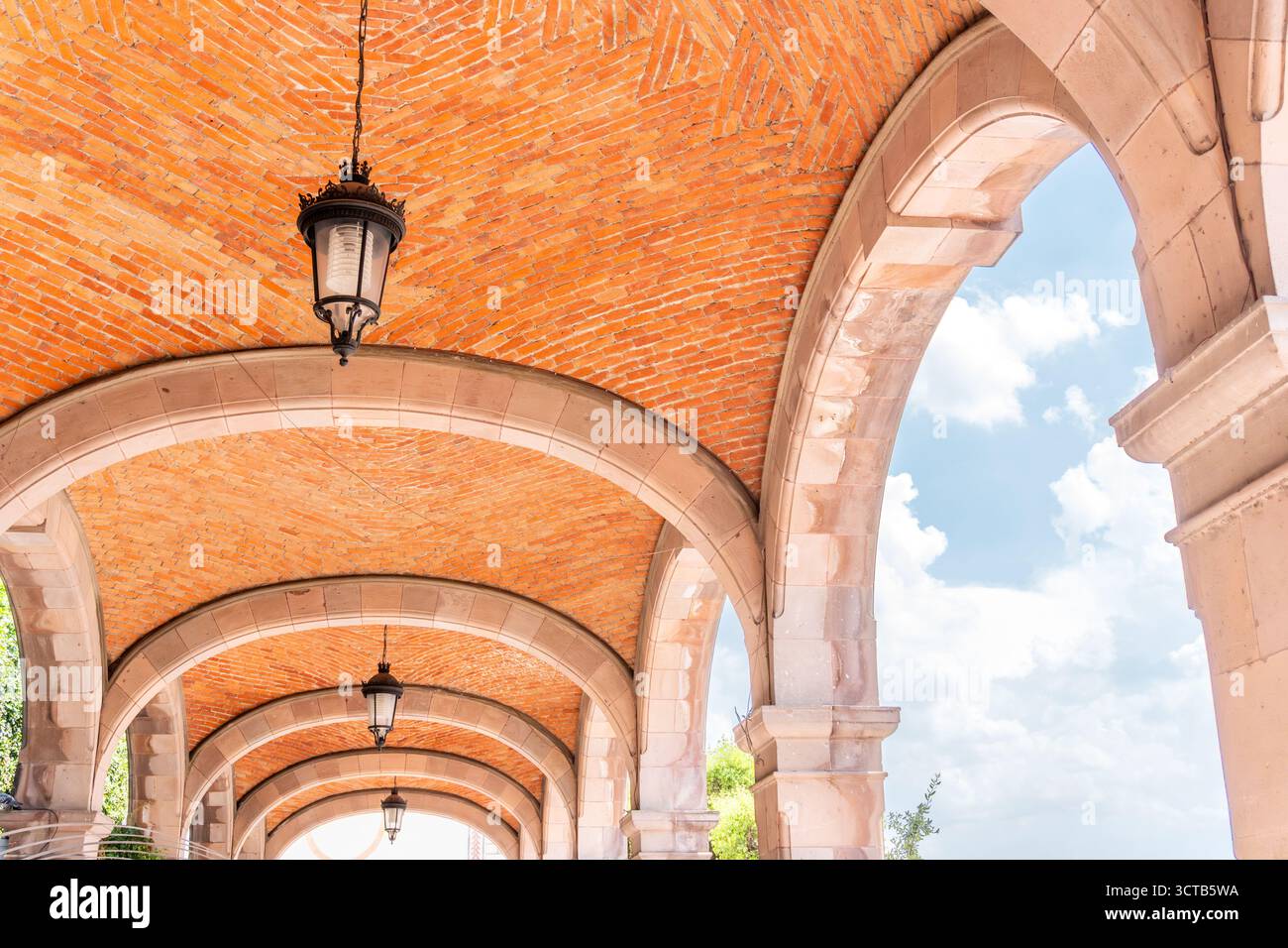 The arched ceiling of a building is lit by a series of lamps. The lamps ...