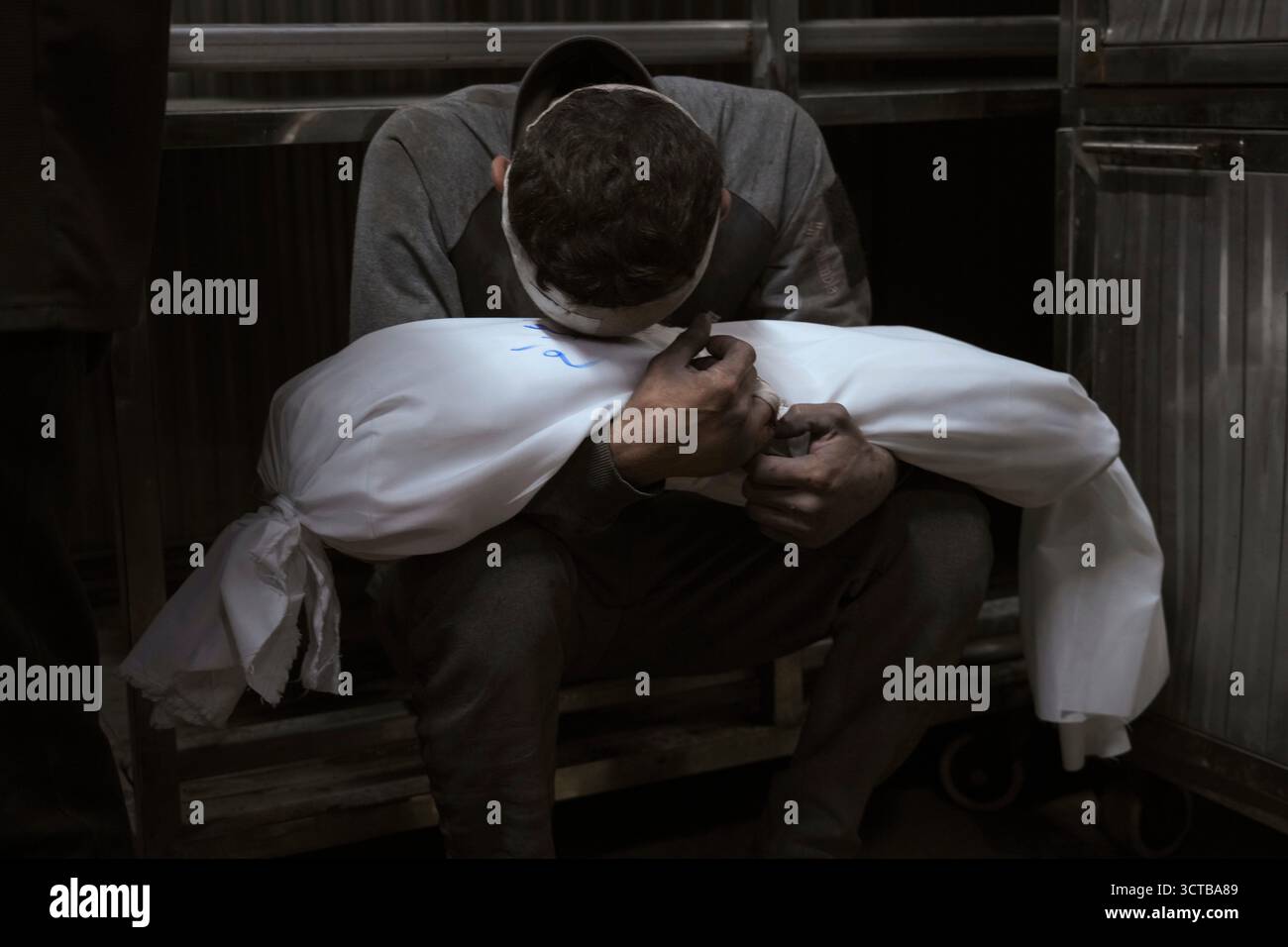 Hossam Azzam holds the body of his child, Amir, who was killed in an ...