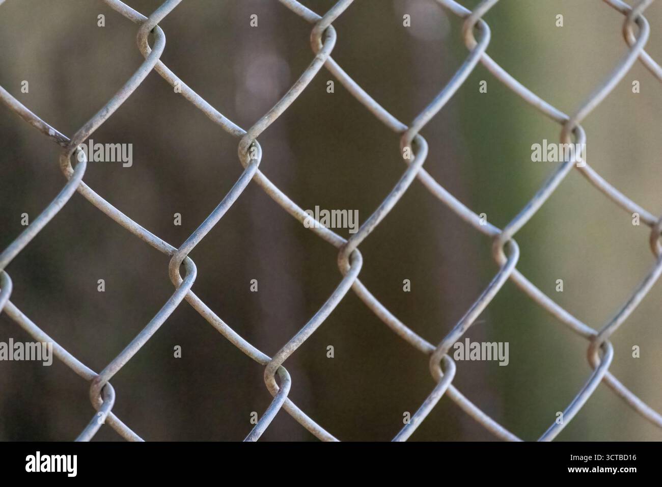 Detail of a worn, rusted metal mesh fence, chain-link pattern. Boundary ...