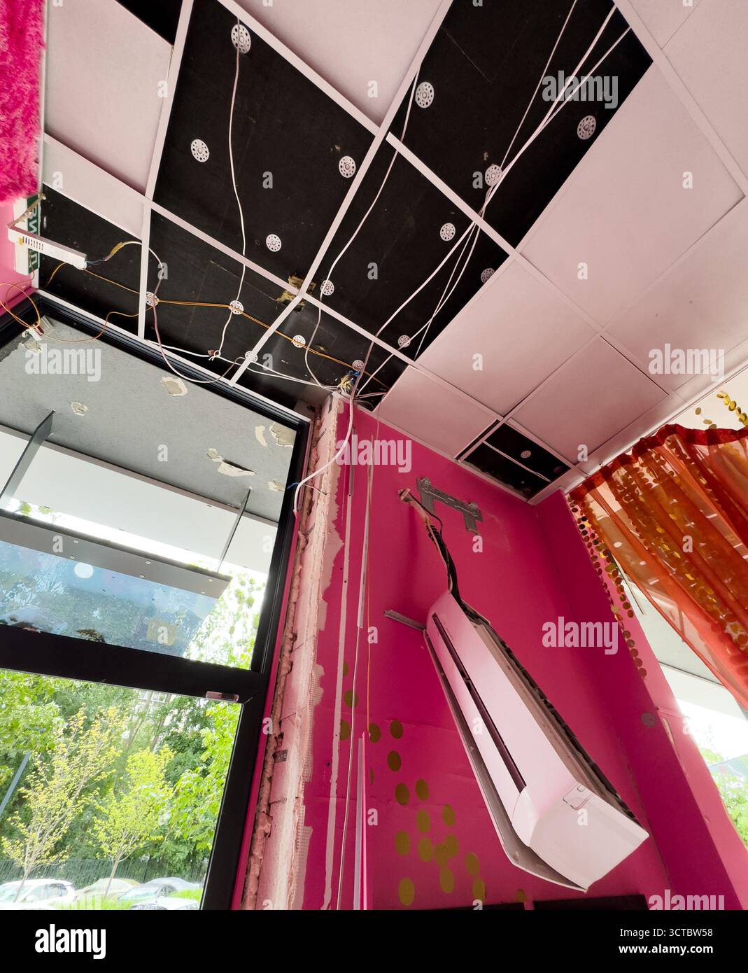 Broken suspended ceiling tiles revealing electrical wiring and ...