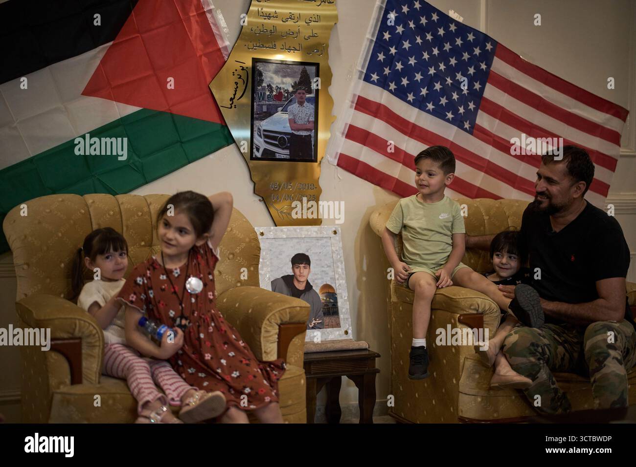 Mohammed Rabee, 48, sits with his grandchildren beside photos of his 14 ...