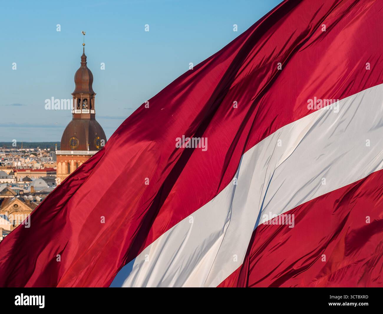 Latvian National Flag with Riga Cathedral Spire in the Background Stock ...