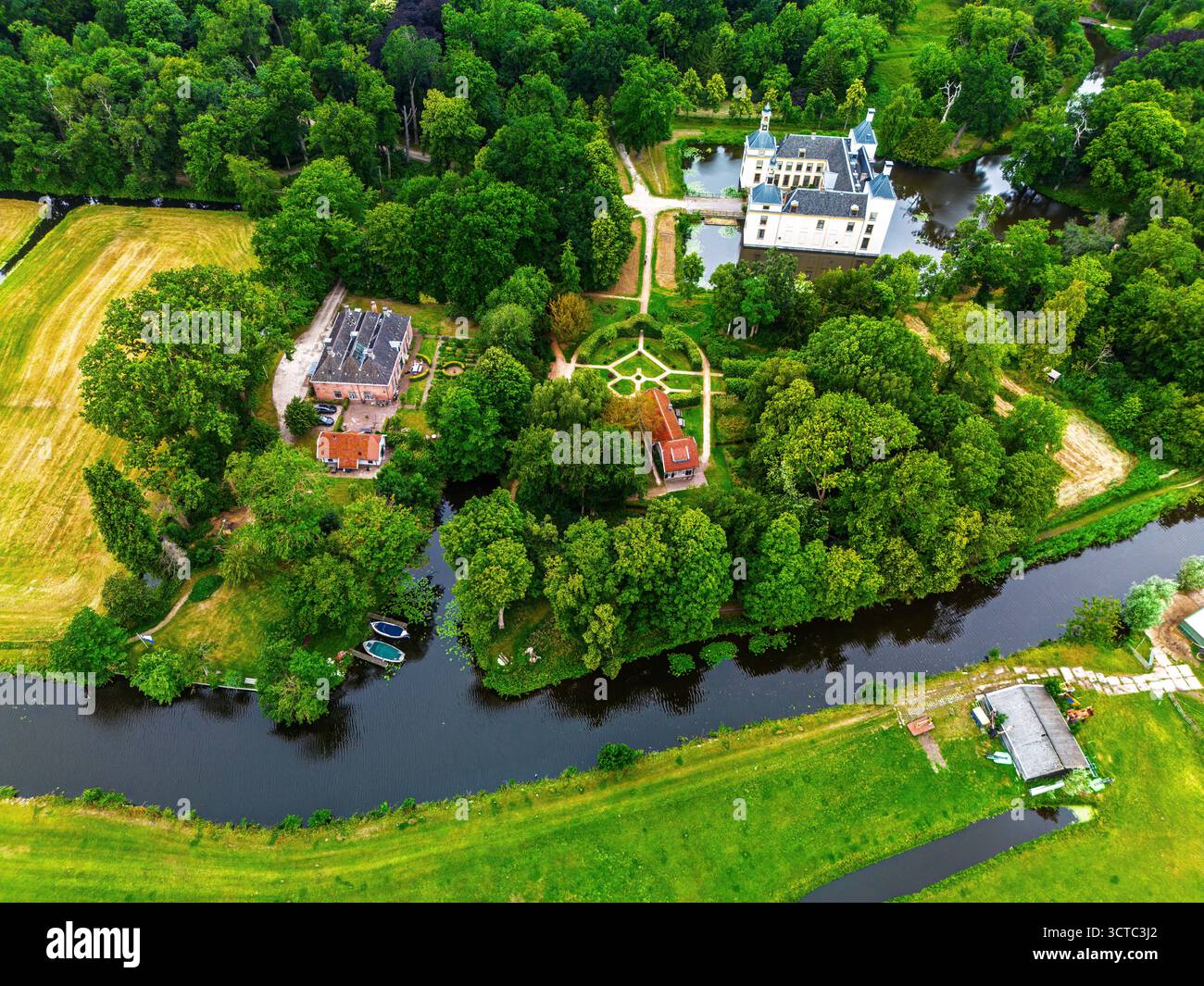 Aerial view of white castle-like estate with moat, formal garden, red ...