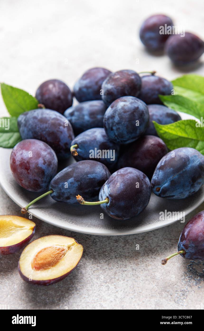 Freshly picked plums with green leaves displaying healthy organic fruit ...
