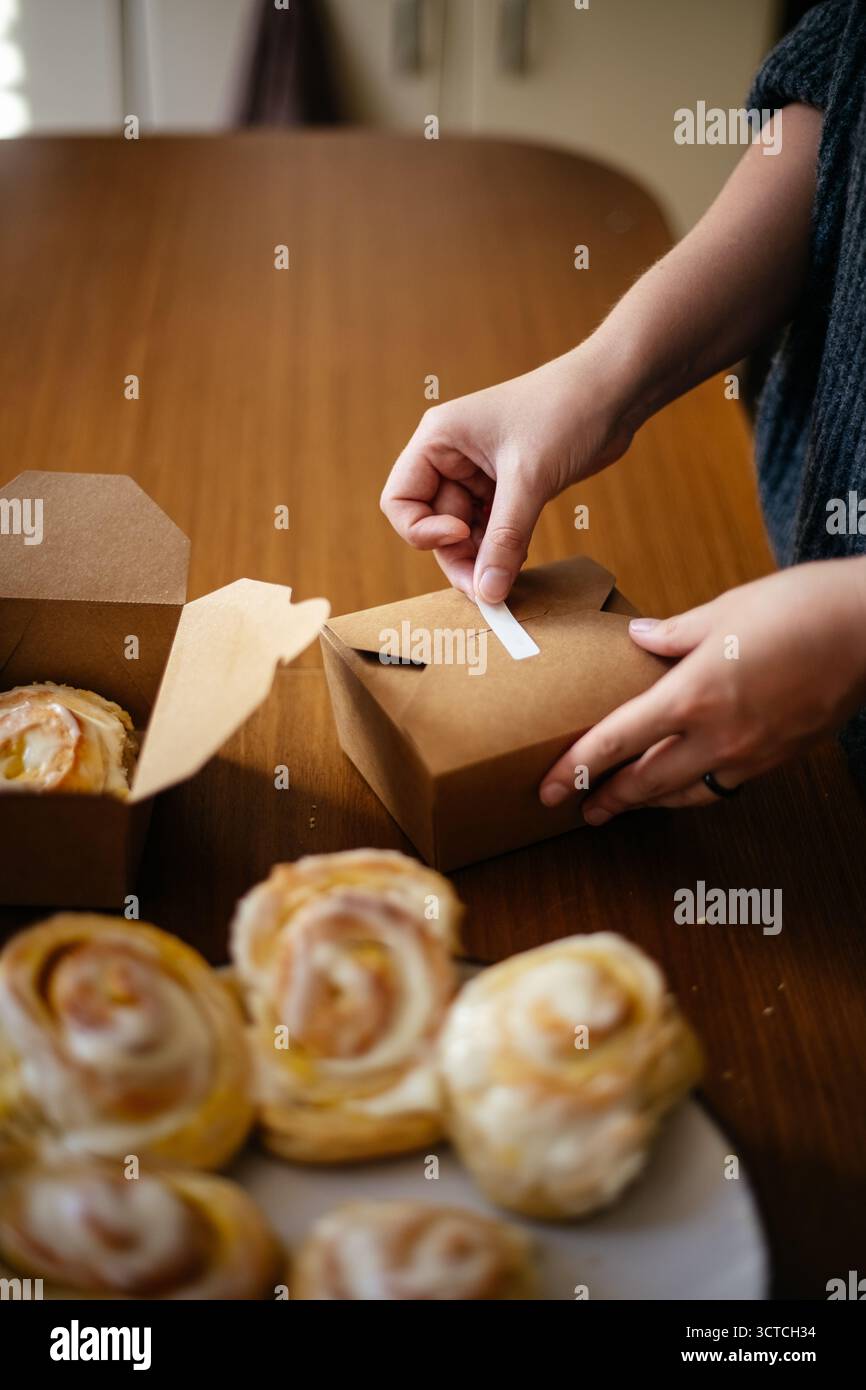 Hand sealing a paper pastry box Stock Photo - Alamy