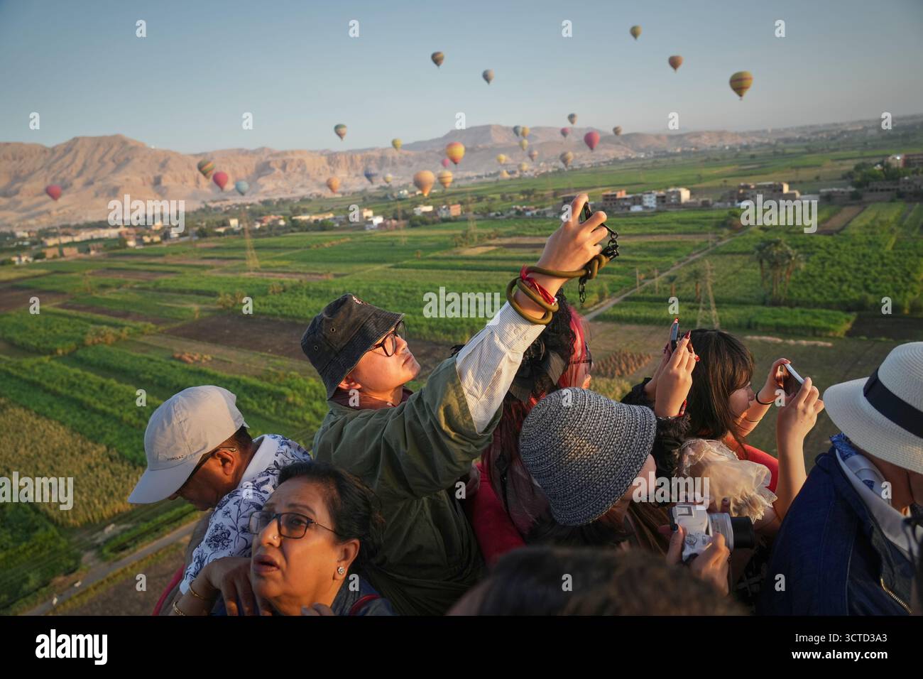 Chinese tourists film during their tour on a hot air balloon on the west bank of the Nile River ...