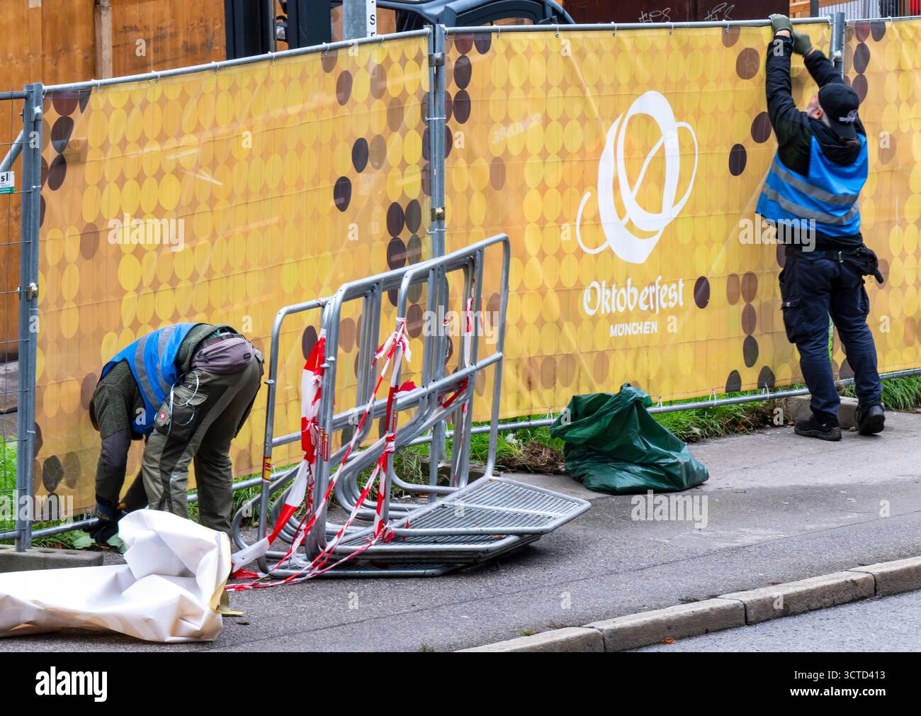 06 October 2025, Bavaria, Munich: Workers remove the privacy screen ...