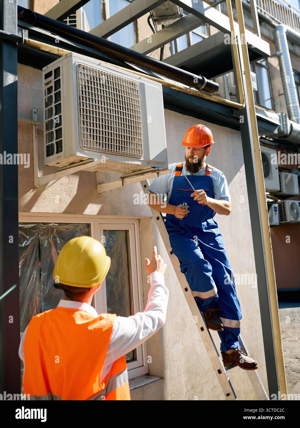 Engineers discussing air conditioner hi-res stock photography and ...