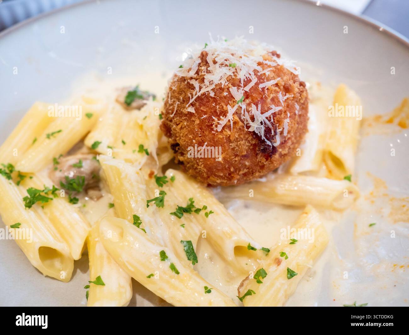 Creamy Penne Pasta with Crispy Arancini Stock Photo - Alamy