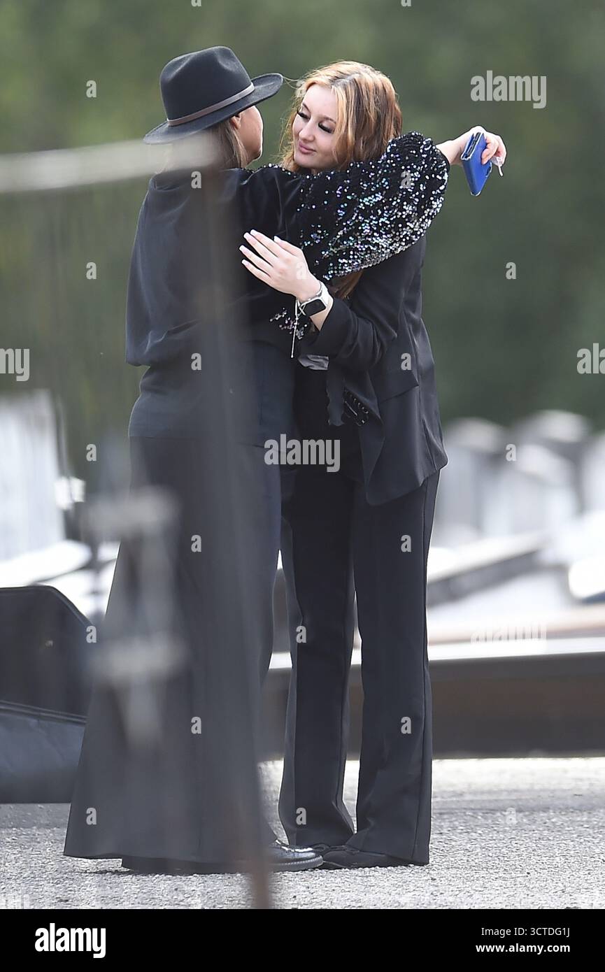 Adrian Daulby's niece (right) hugs one of the mourners as she leaves ...